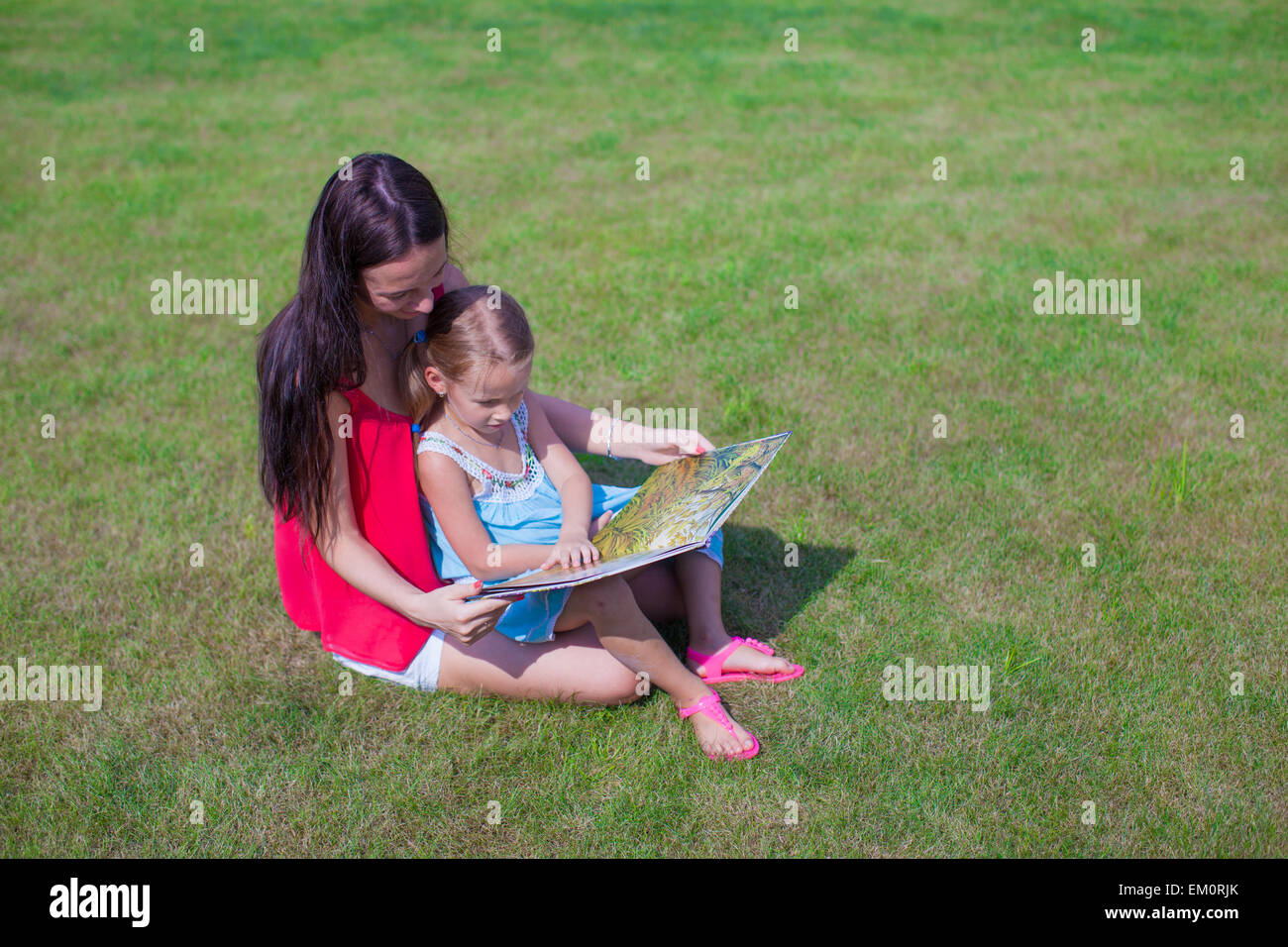 Adorable mother and cute daughter read book and enjoy holiday Stock ...