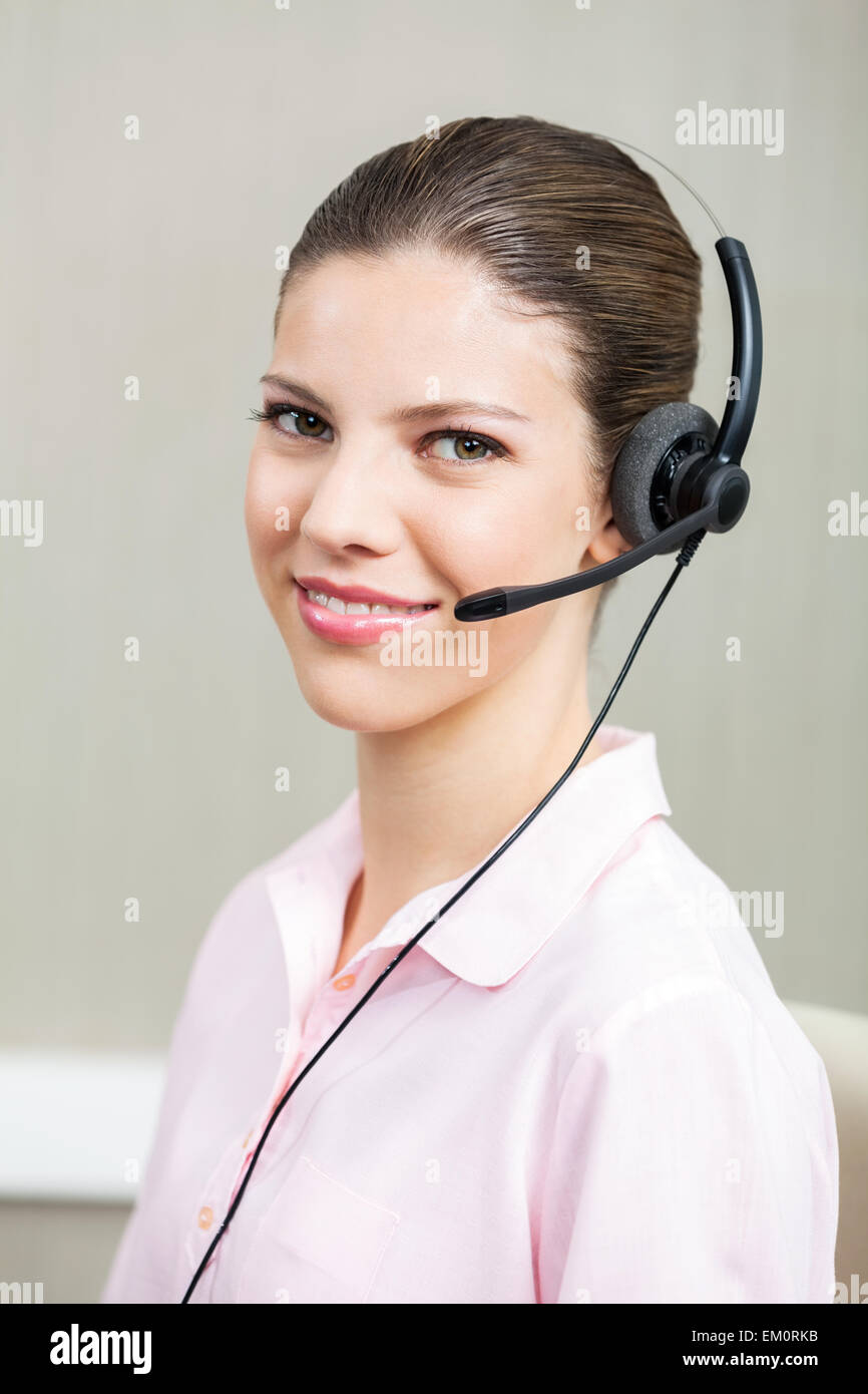 Smiling Female Call Center Employee Using Headphones Stock Photo - Alamy