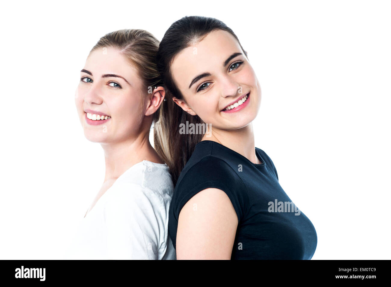 Happy teen girls standing back to back Stock Photo - Alamy