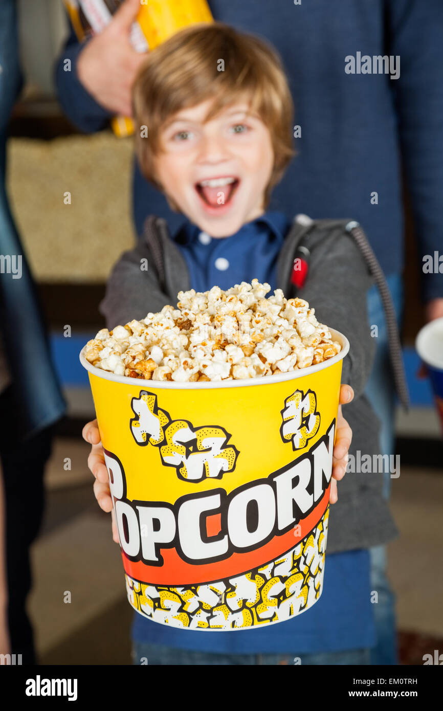 Portrait Of Excited Boy Offering Popcorn Bucket At Cinema Stock Photo ...
