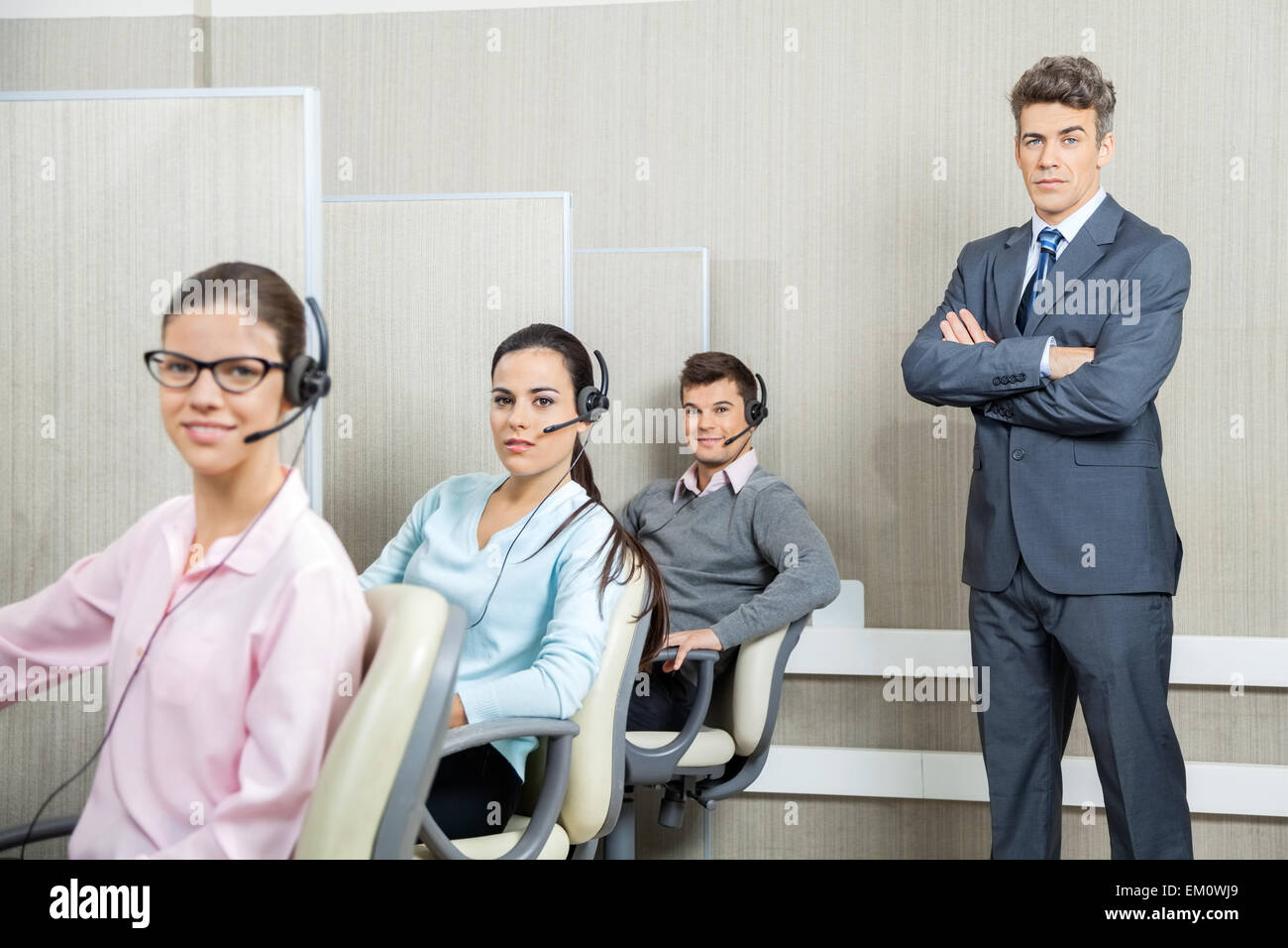 Confident Businessman Standing By Team In Call Center Stock Photo - Alamy