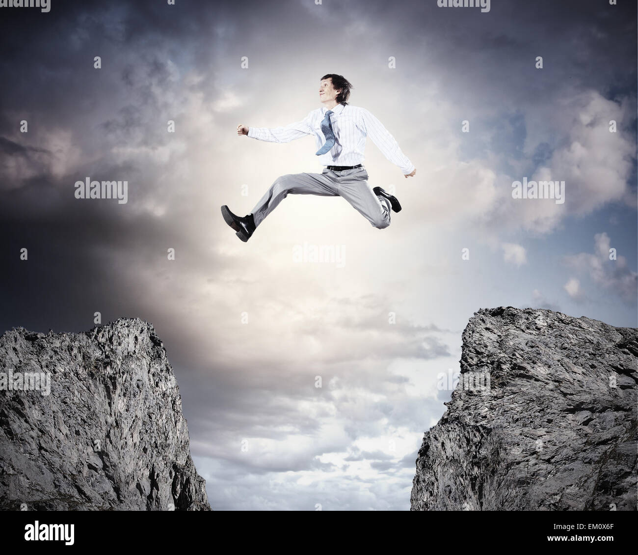 Businessman jumping over gap Stock Photo - Alamy