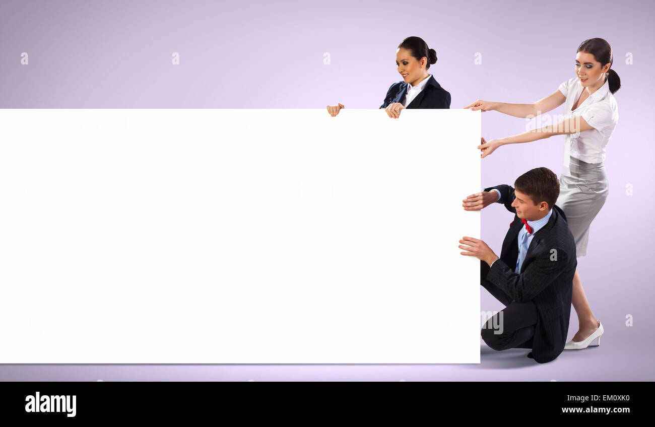 Three young people holding banner Stock Photo - Alamy