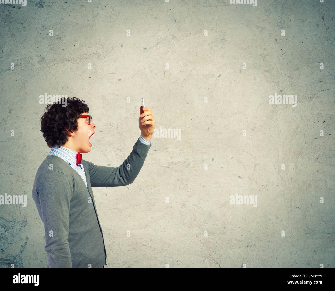 Young man shouting at his mobile phone Stock Photo - Alamy