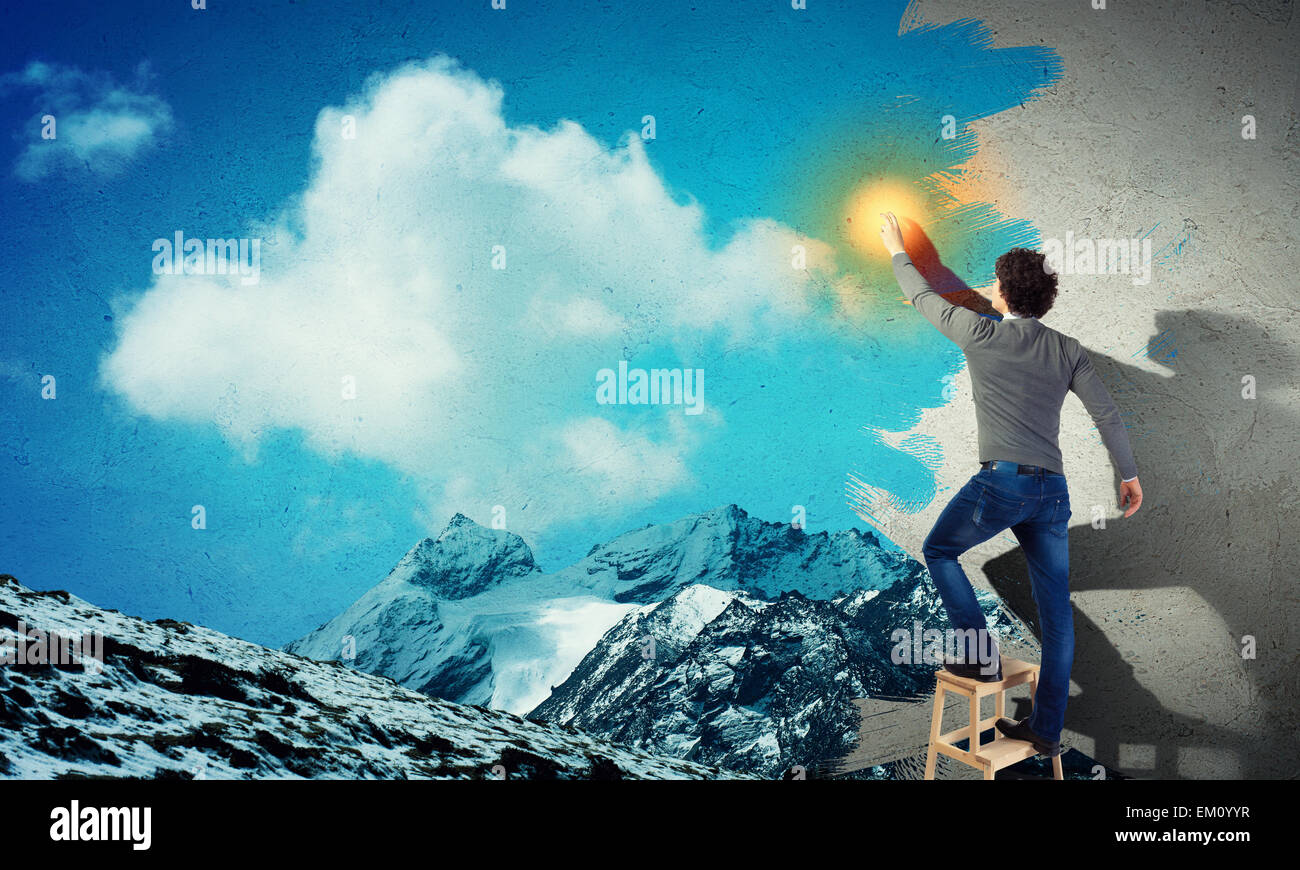 Young man drawing a cloudy blue sky Stock Photo - Alamy