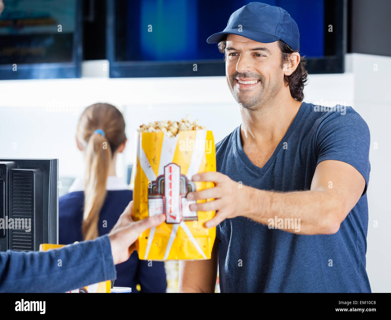 Happy Seller Selling Popcorn To Man At Concession Stand Stock Photo - Alamy