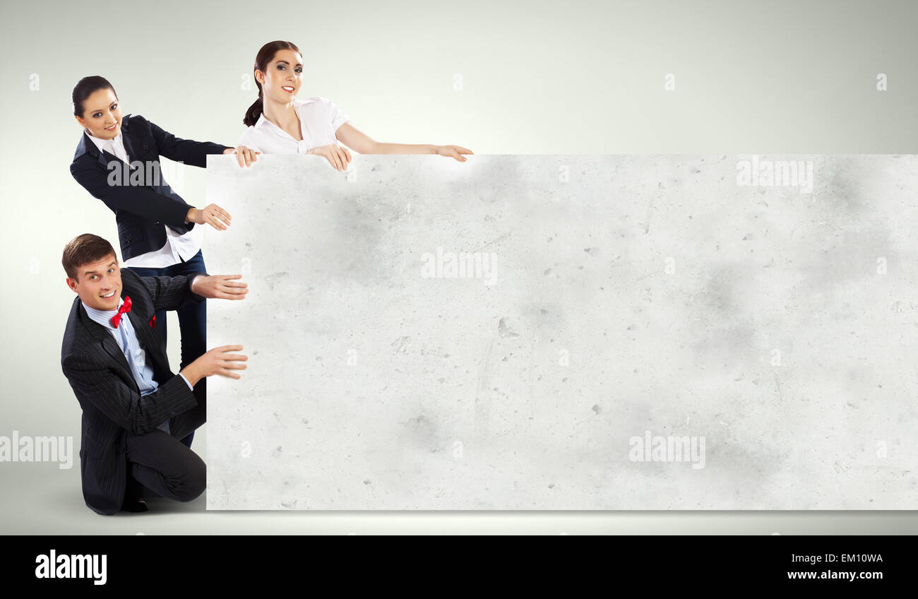 Three young people holding banner Stock Photo - Alamy