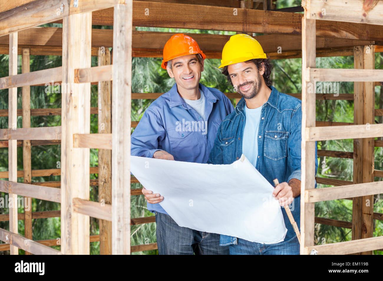 Confident Construction Workers With Blueprint At Site Stock Photo - Alamy
