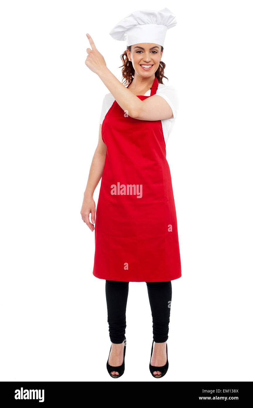 Full length portrait of female chef pointing away Stock Photo - Alamy
