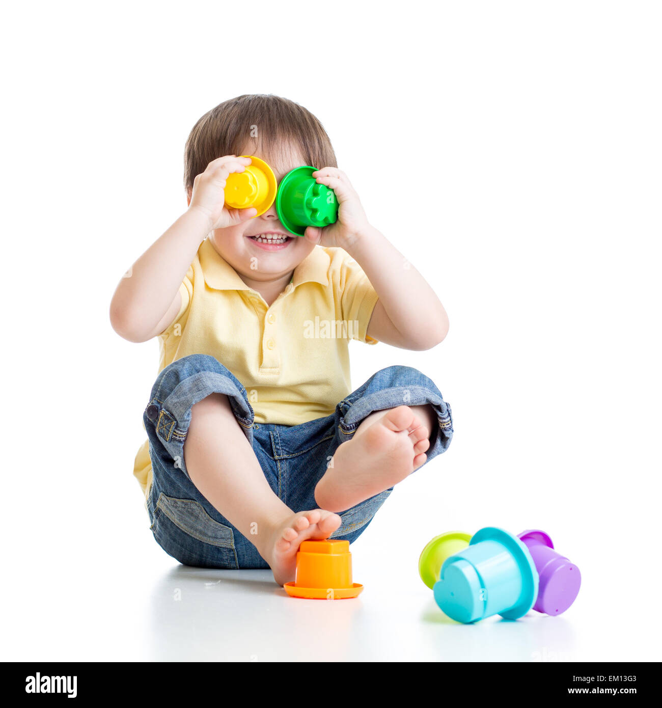 little child is playing with toys while sitting on floor, isolated over ...