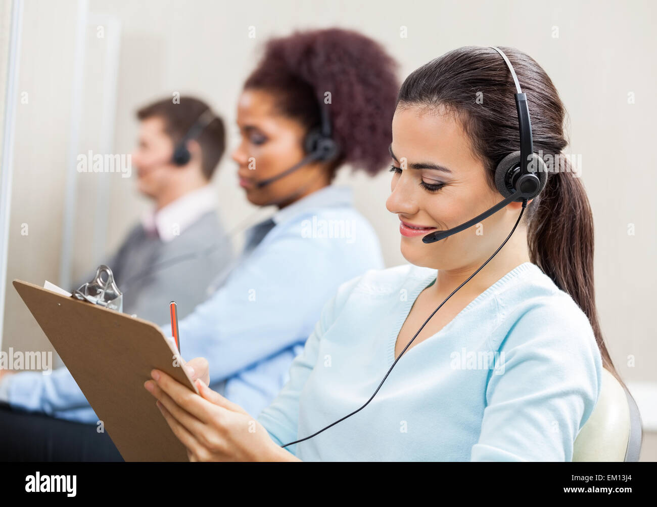 Customer Service Representative Writing On Clipboard In Office Stock Photo - Alamy