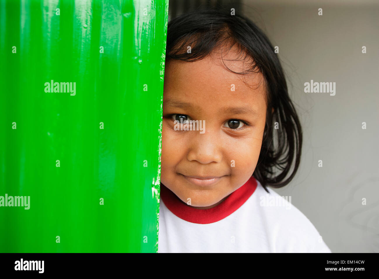 Young girl posing by a green wall, near Banda Aceh; Lhok Nga, Aceh ...