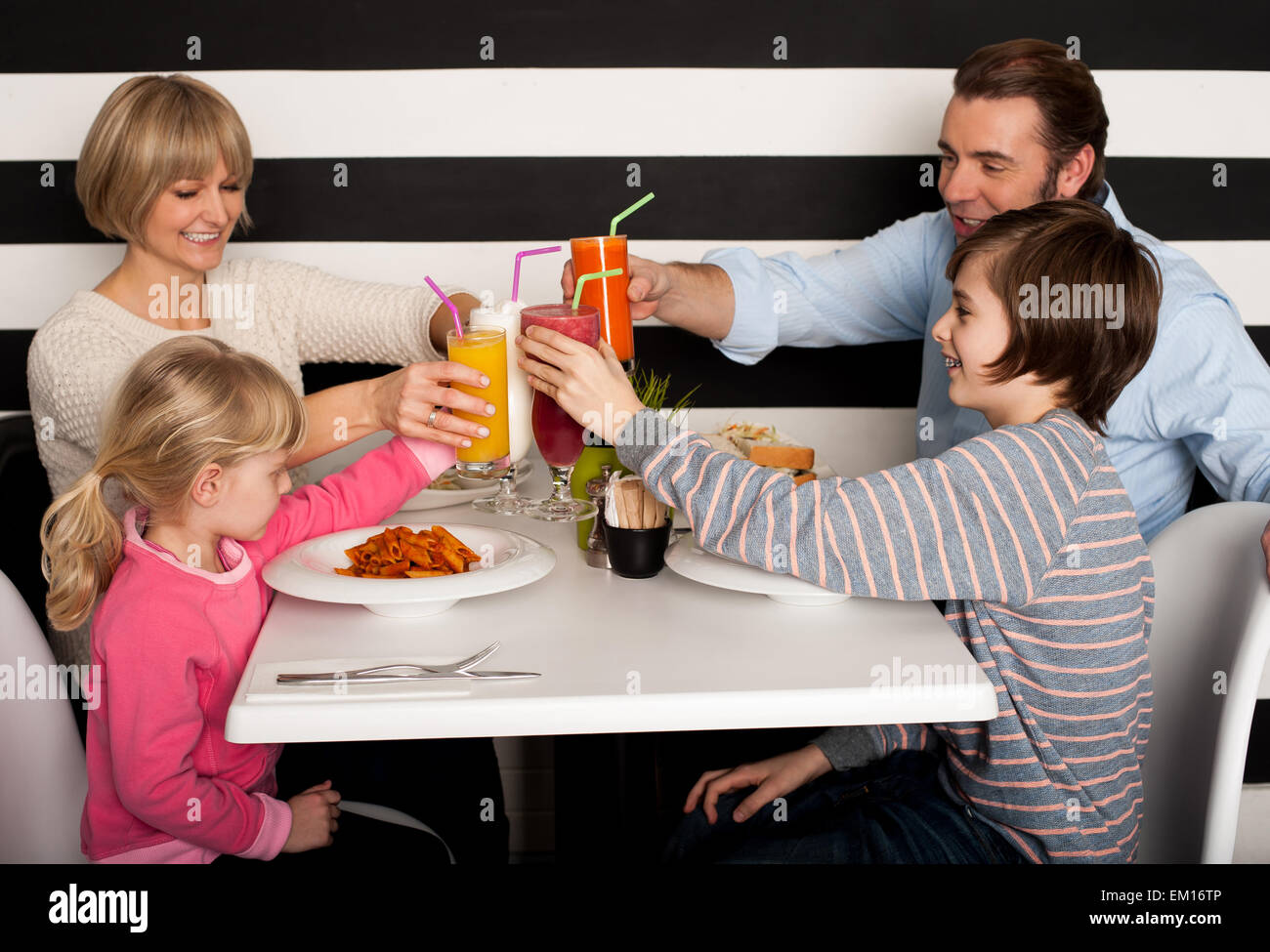 Family toasting smoothies in restaurant Stock Photo - Alamy