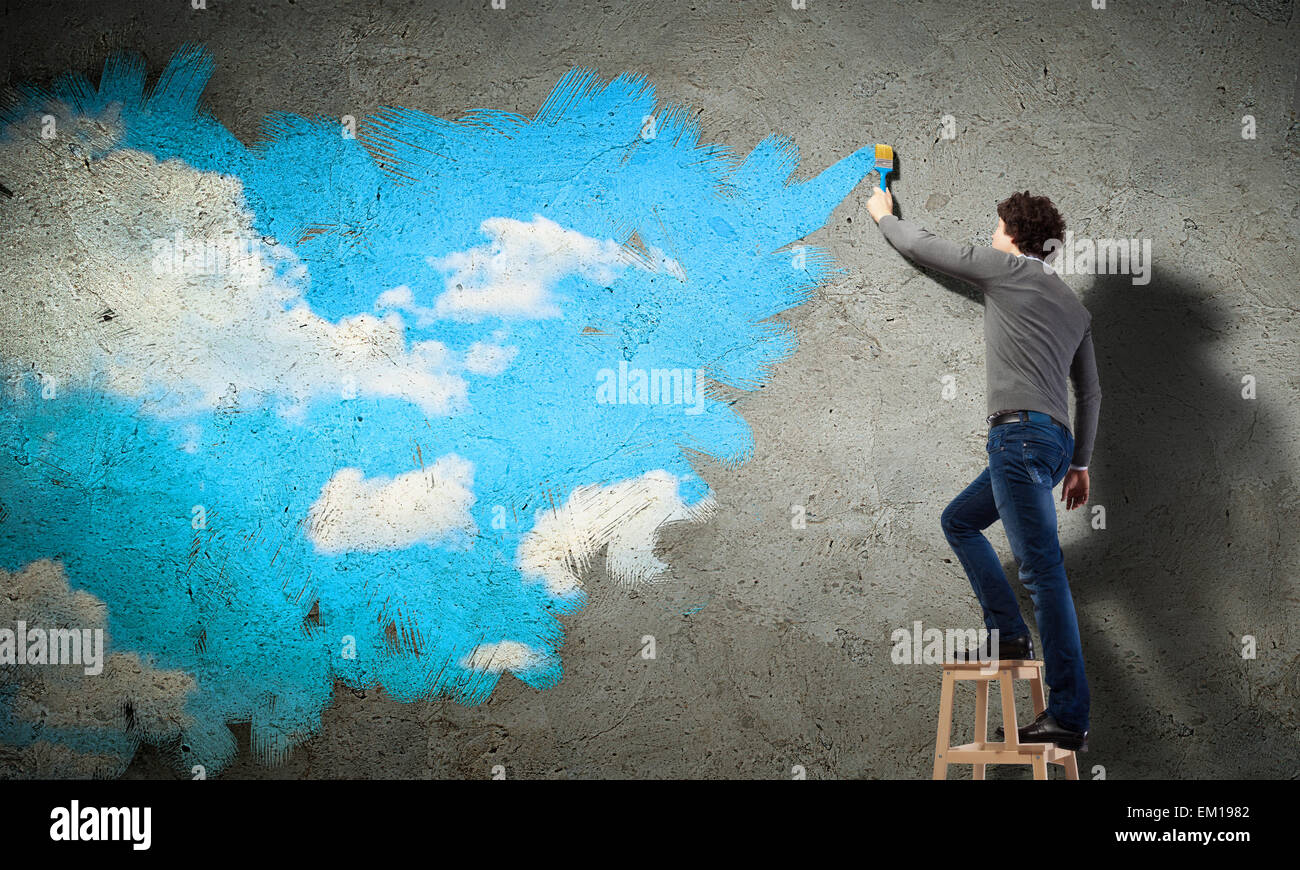 Young man drawing a cloudy blue sky Stock Photo - Alamy
