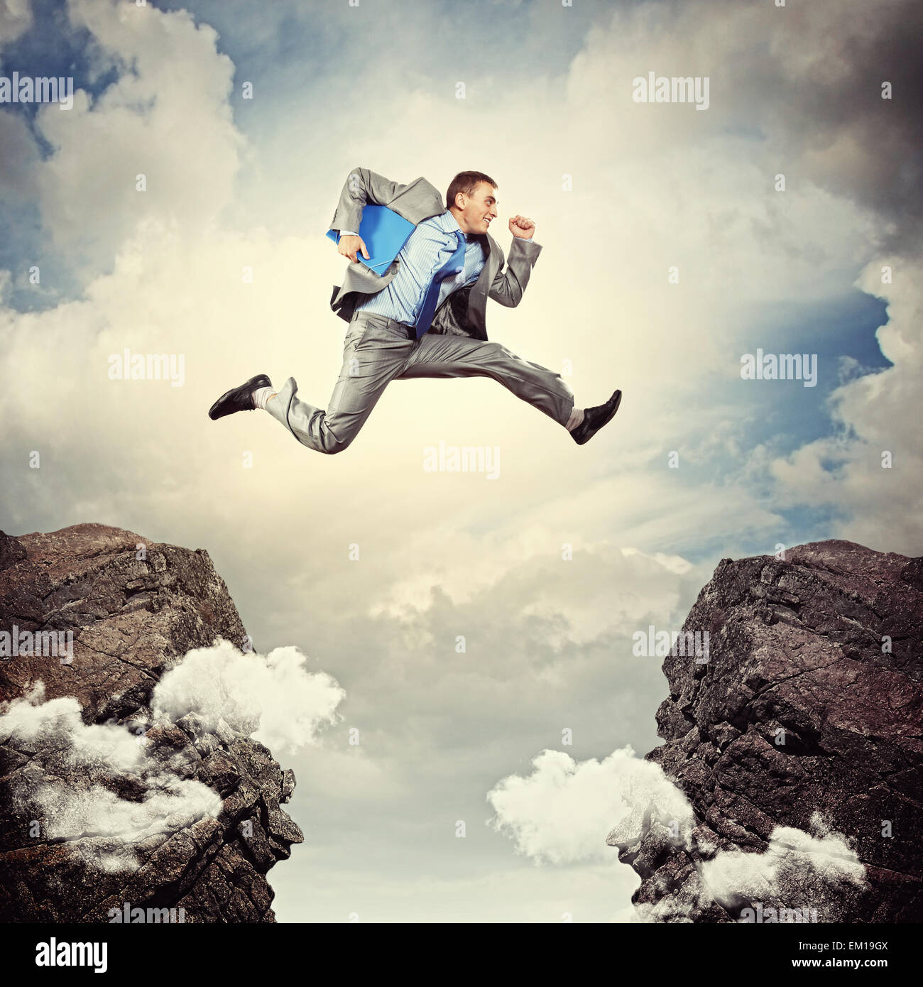 Businessman jumping over gap Stock Photo - Alamy