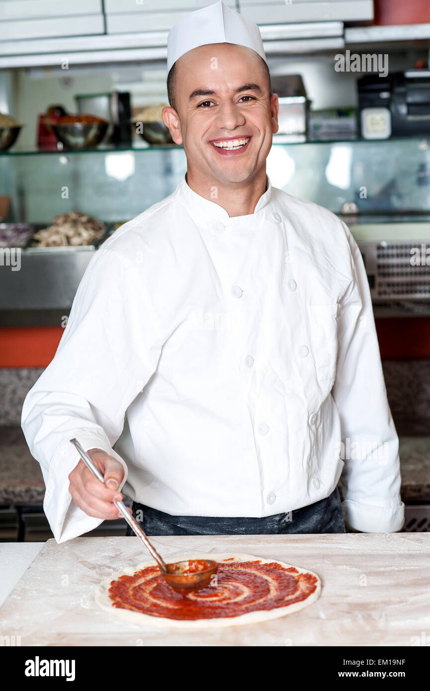 Smiling chef making pizza Stock Photo - Alamy