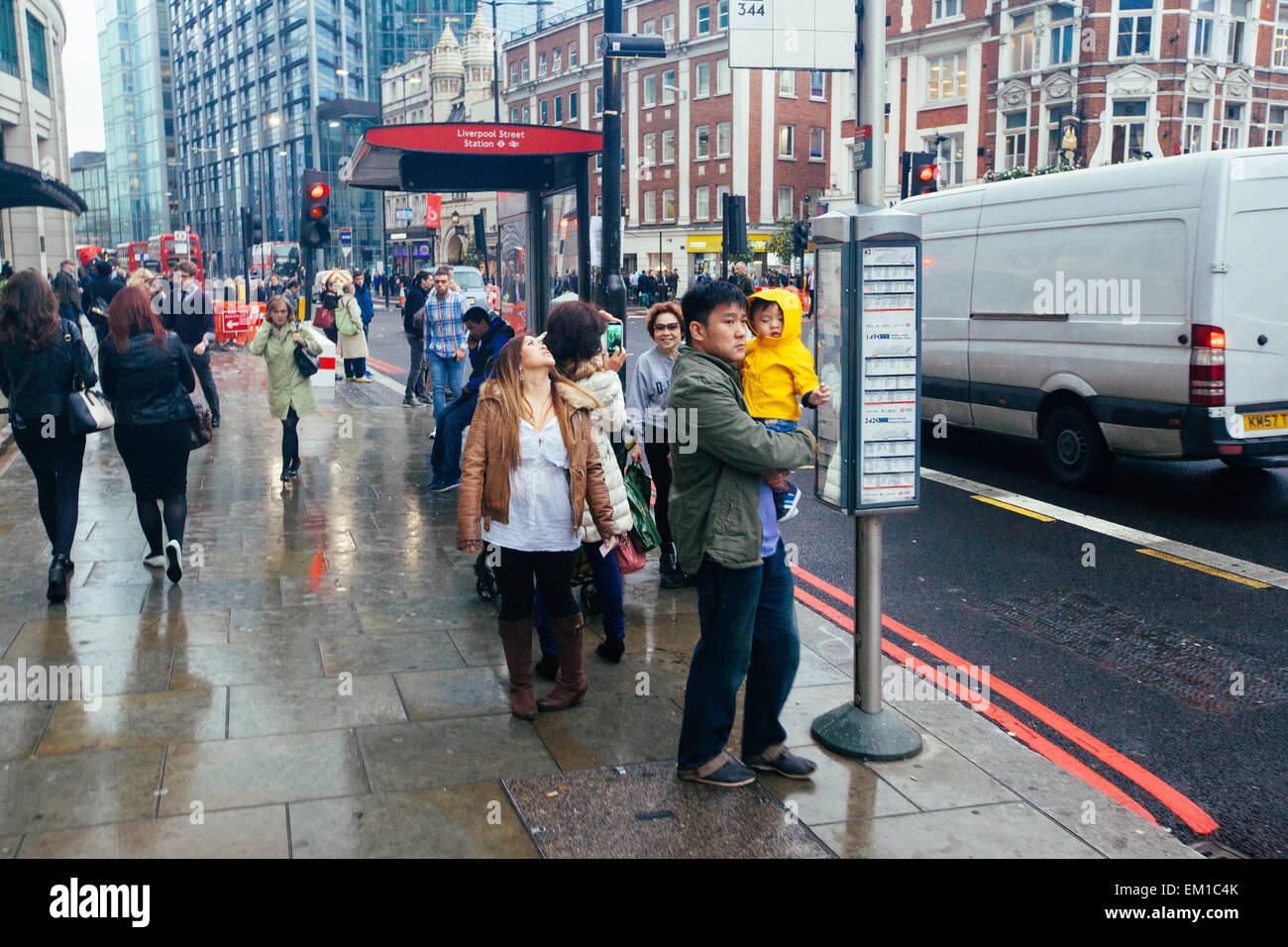 Bus stop in London while raining. Parent holding his kid Stock Photo ...