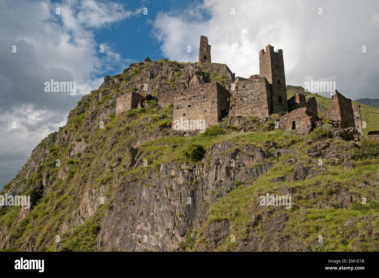 Mutso fortress (Georgia) on the mountain top. Blue sky with clouds are ...