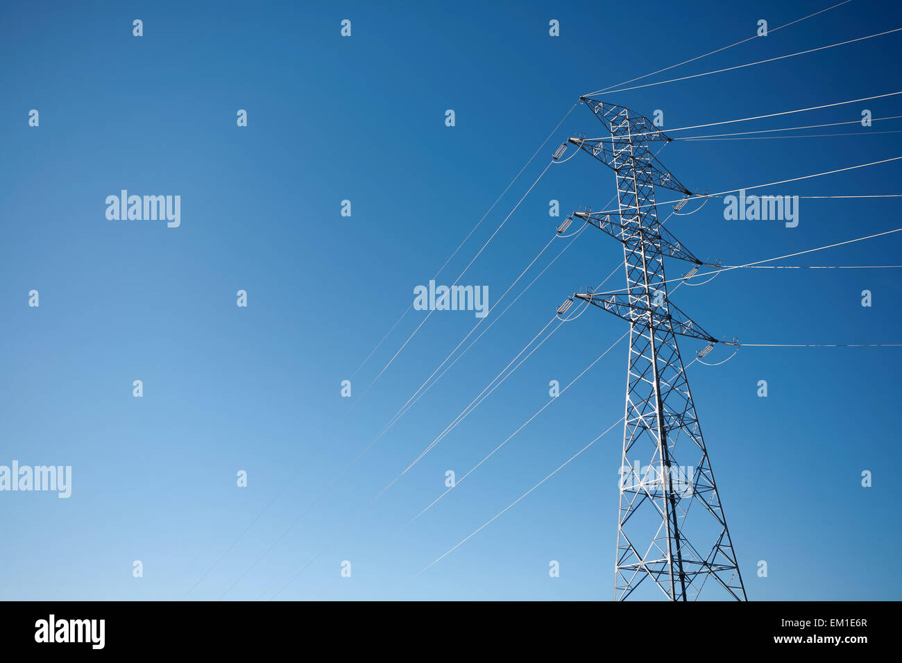 High tension electrical power lines and pylon tower against sky. Modern ...