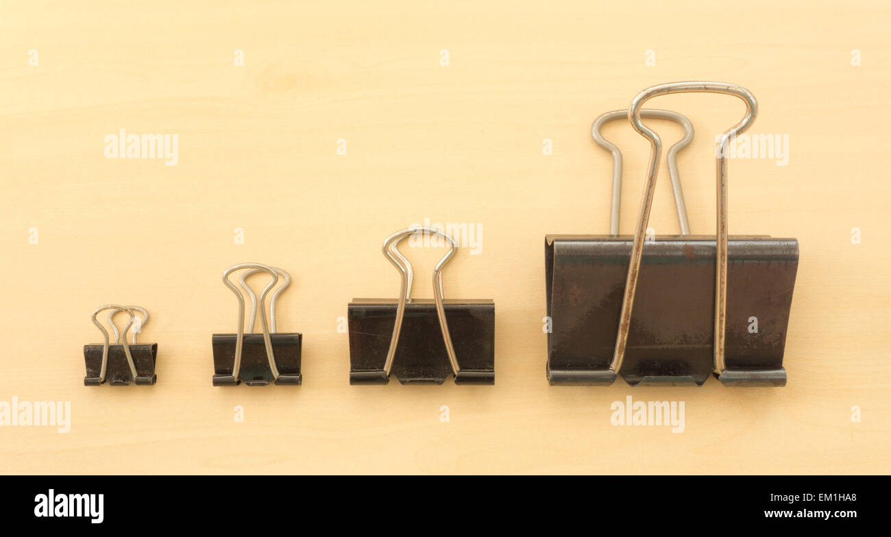 Four Different Size of Black Paper Clips on Wooden Surface Table Stock ...