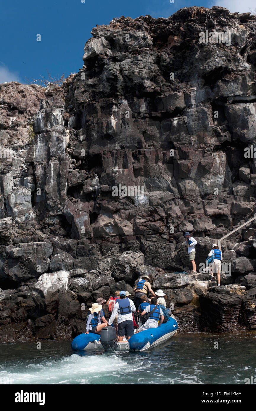 A Group Of People Disembark An Inflatable Raft Onto Rugged Terrain ...