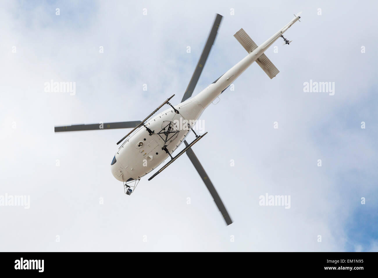 white flying helicopter transporting cargo in the Dolomites, view the ...