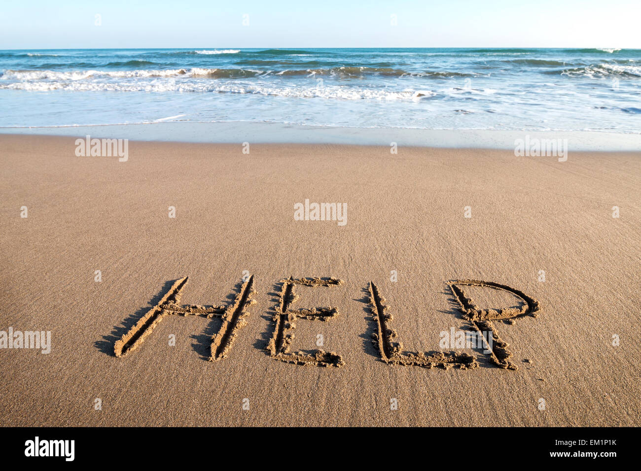 Drawing HELP on the sand Stock Photo - Alamy