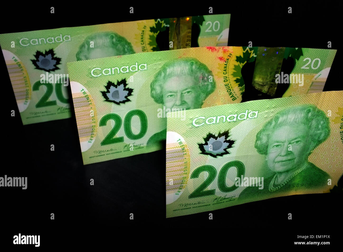 Canadian $20 notes photographed against a black background Stock Photo ...