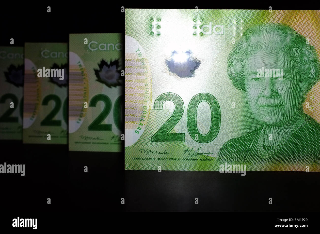 Canadian $20 notes photographed against a black background Stock Photo ...