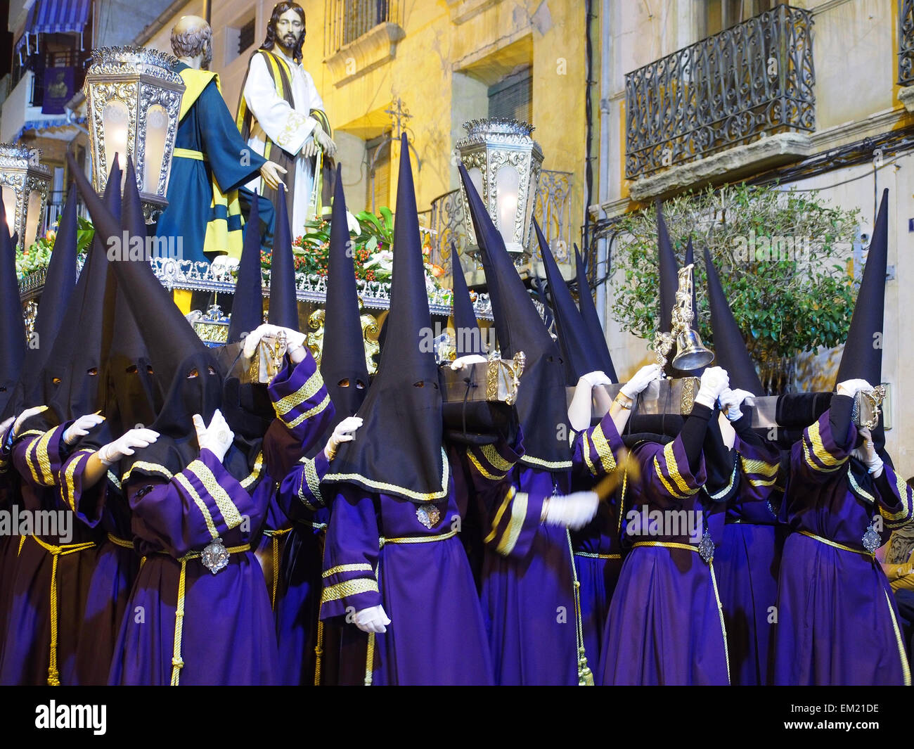 Nazarenos carrying a trono (religious float) in a night time procession ...