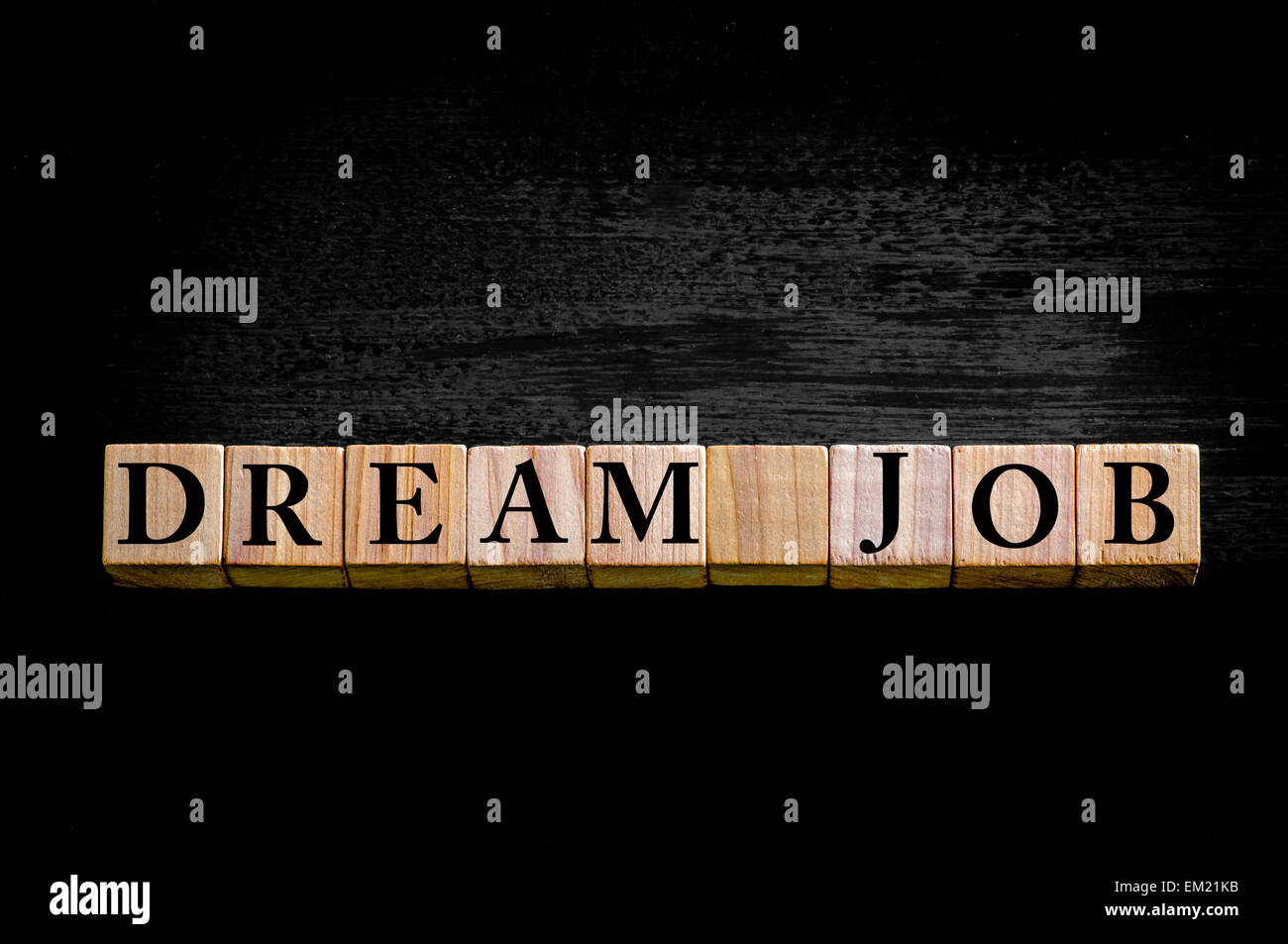 Message DREAM JOB. Wooden small cubes with letters isolated on black ...