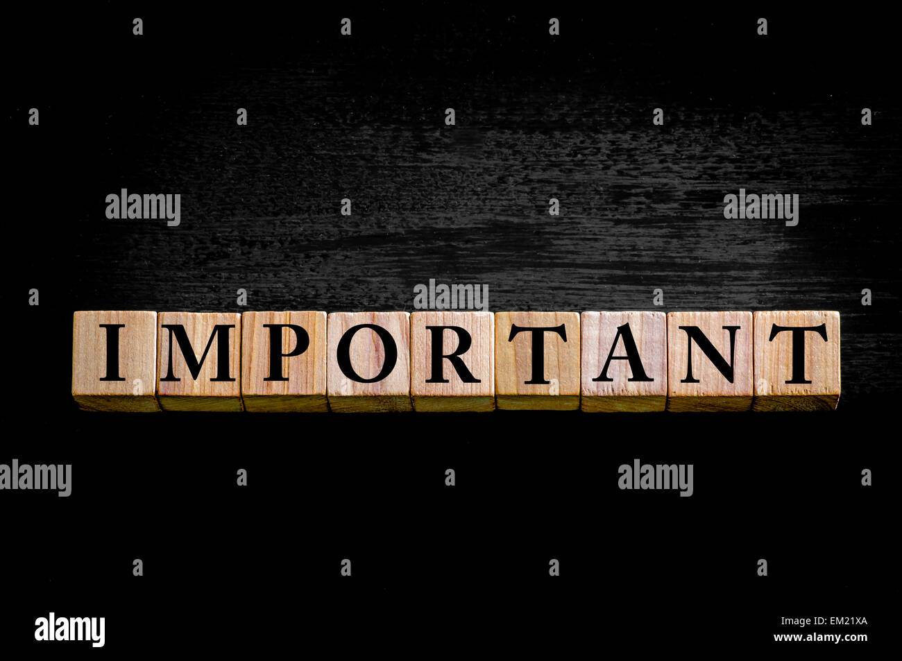 Word IMPORTANT. Wooden small cubes with letters isolated on black ...