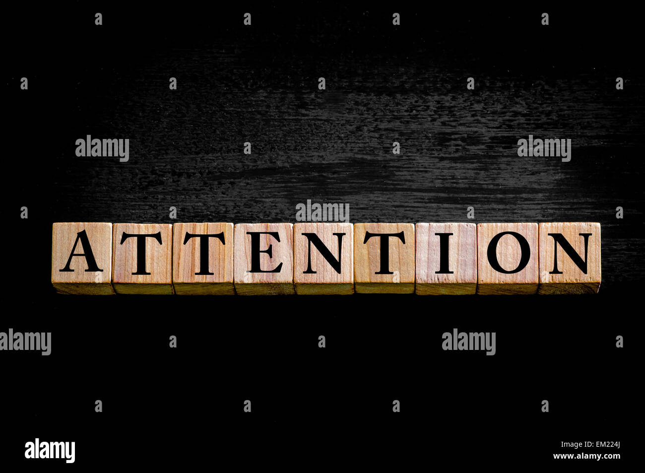 Word ATTENTION. Wooden small cubes with letters isolated on black ...