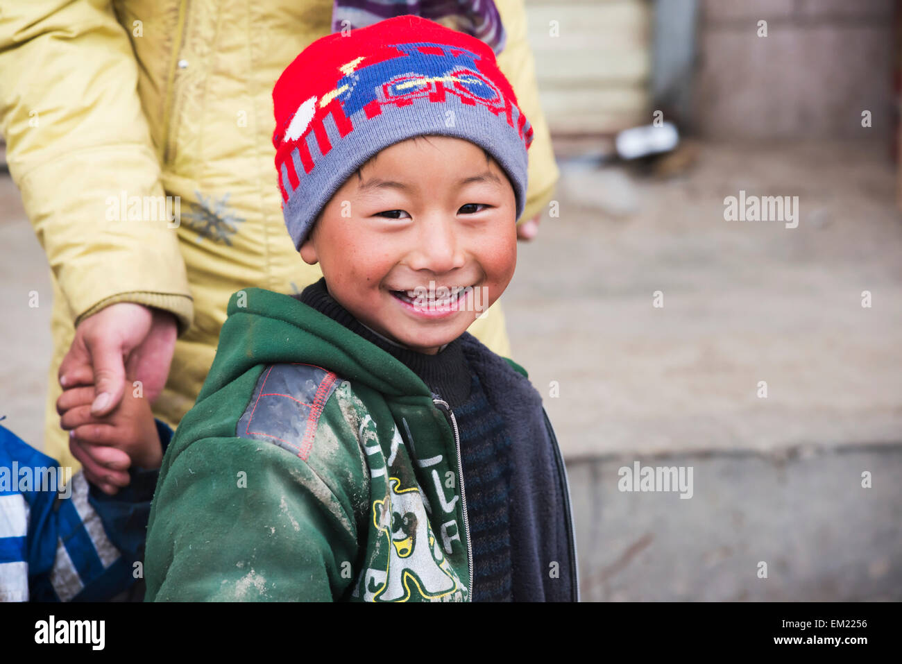 Smiling Tibetan child on a street; Gade city, Qinghai province, Tibet ...
