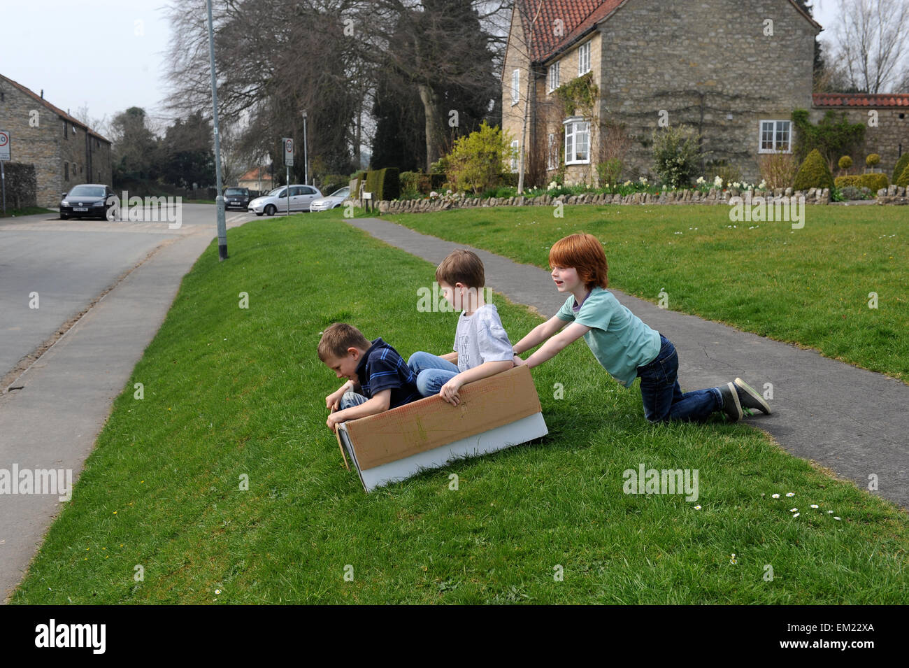 Children playing outside with a cardboard box in Helmsley, North ...