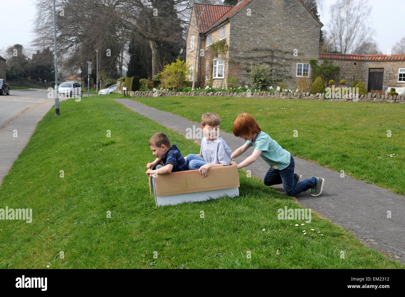 Children playing outside with a cardboard box in Helmsley, North ...