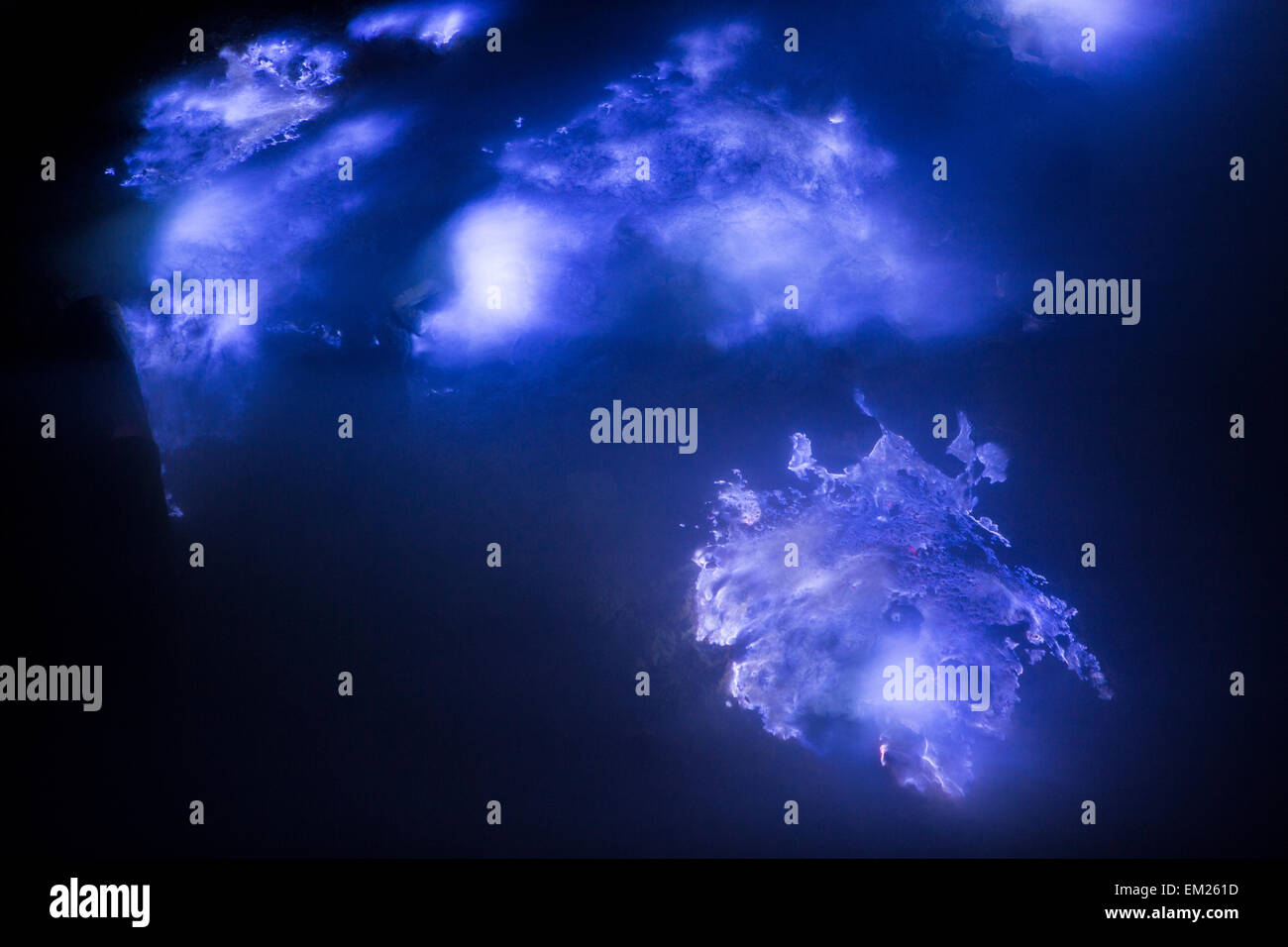 Blue flames of molten sulfur burning at the mine inside the crater of ...