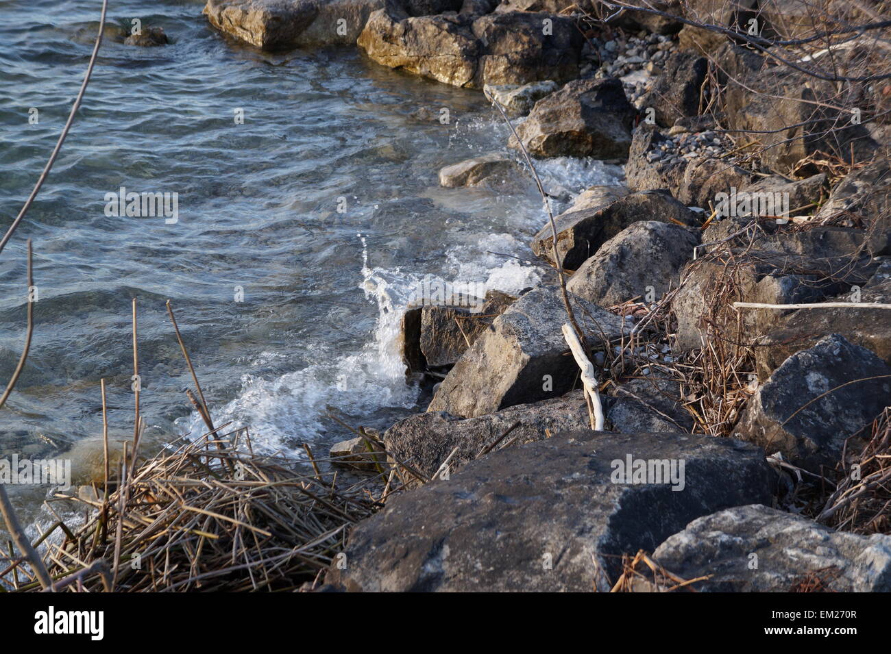 Small waves splashing onto rocks Stock Photo - Alamy