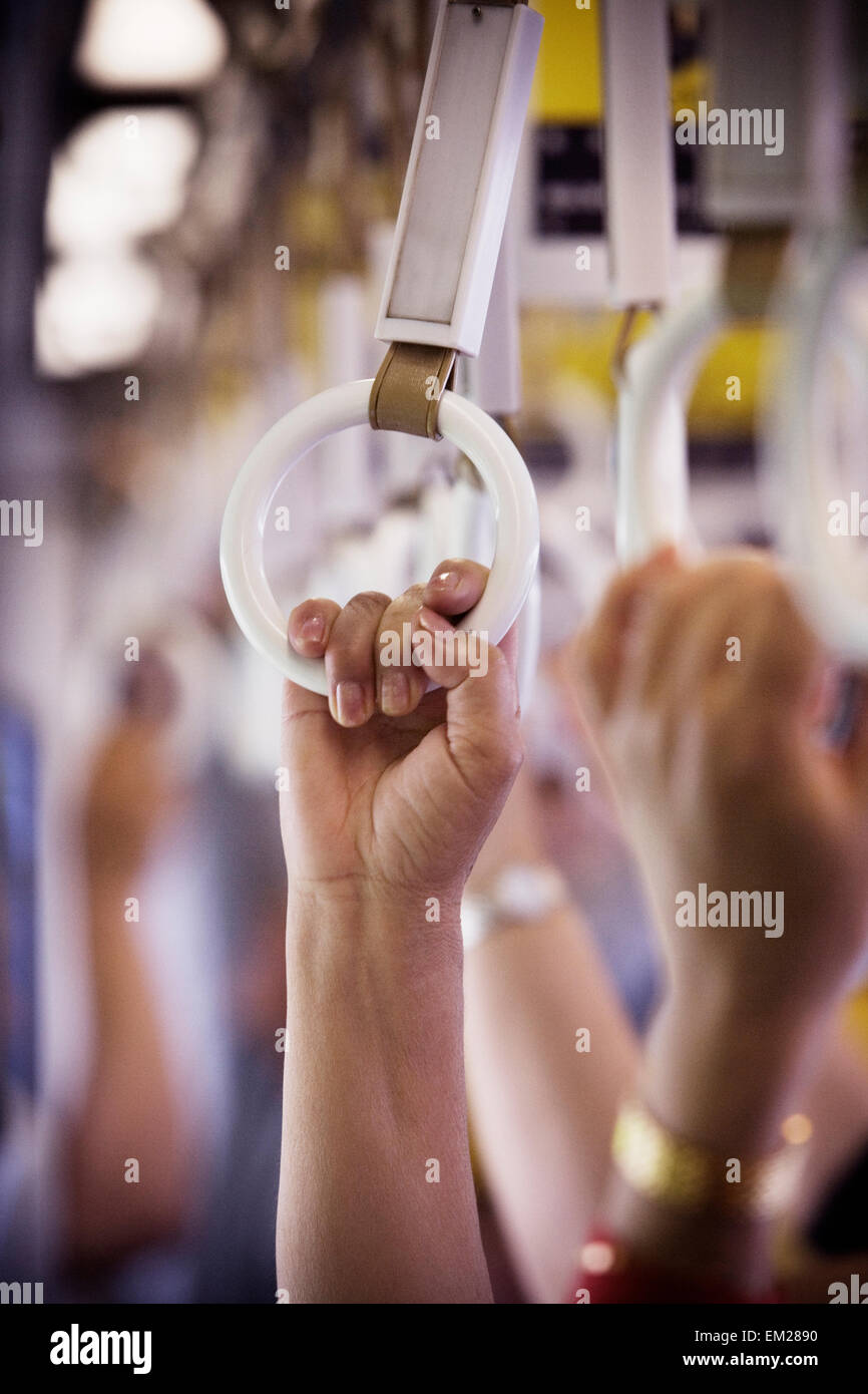 Hands holding hanging handles Stock Photo - Alamy