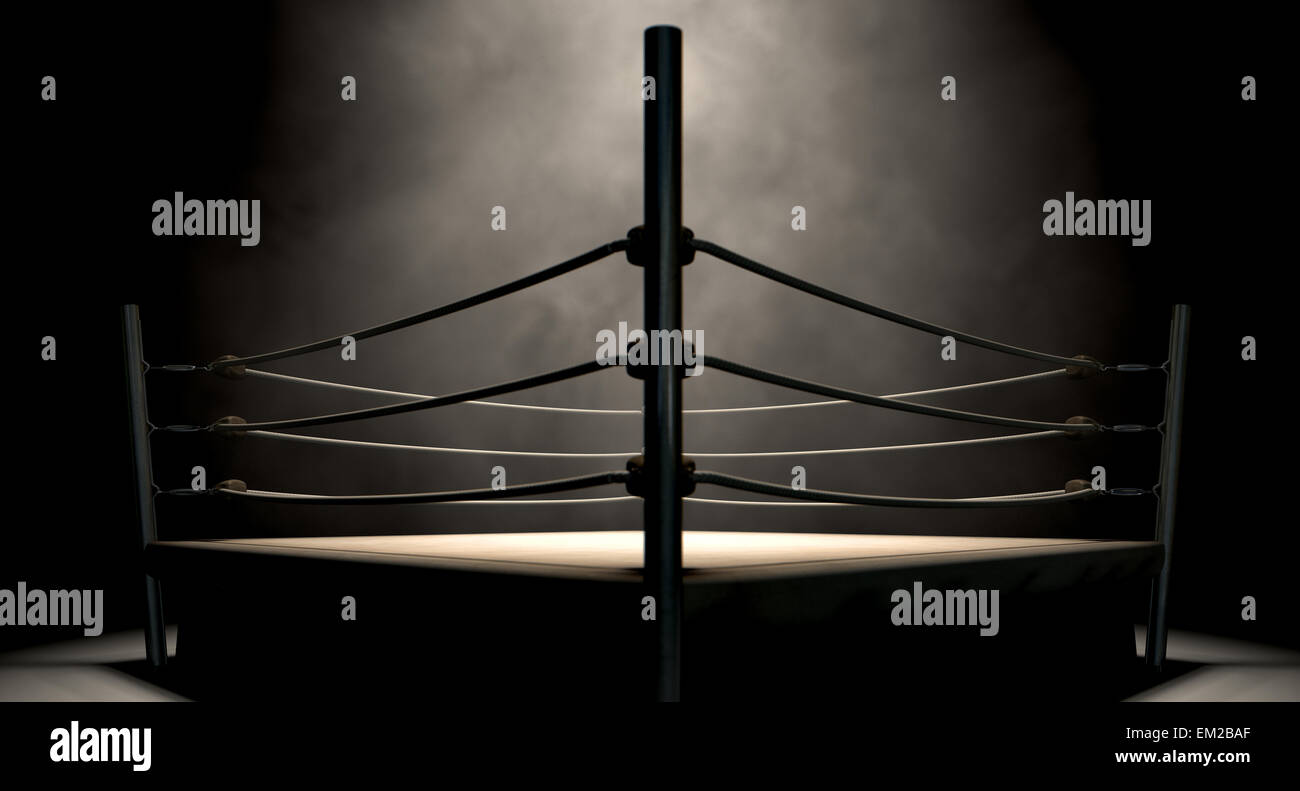 An old vintage boxing ring surrounded by ropes spotlit in the middle on ...