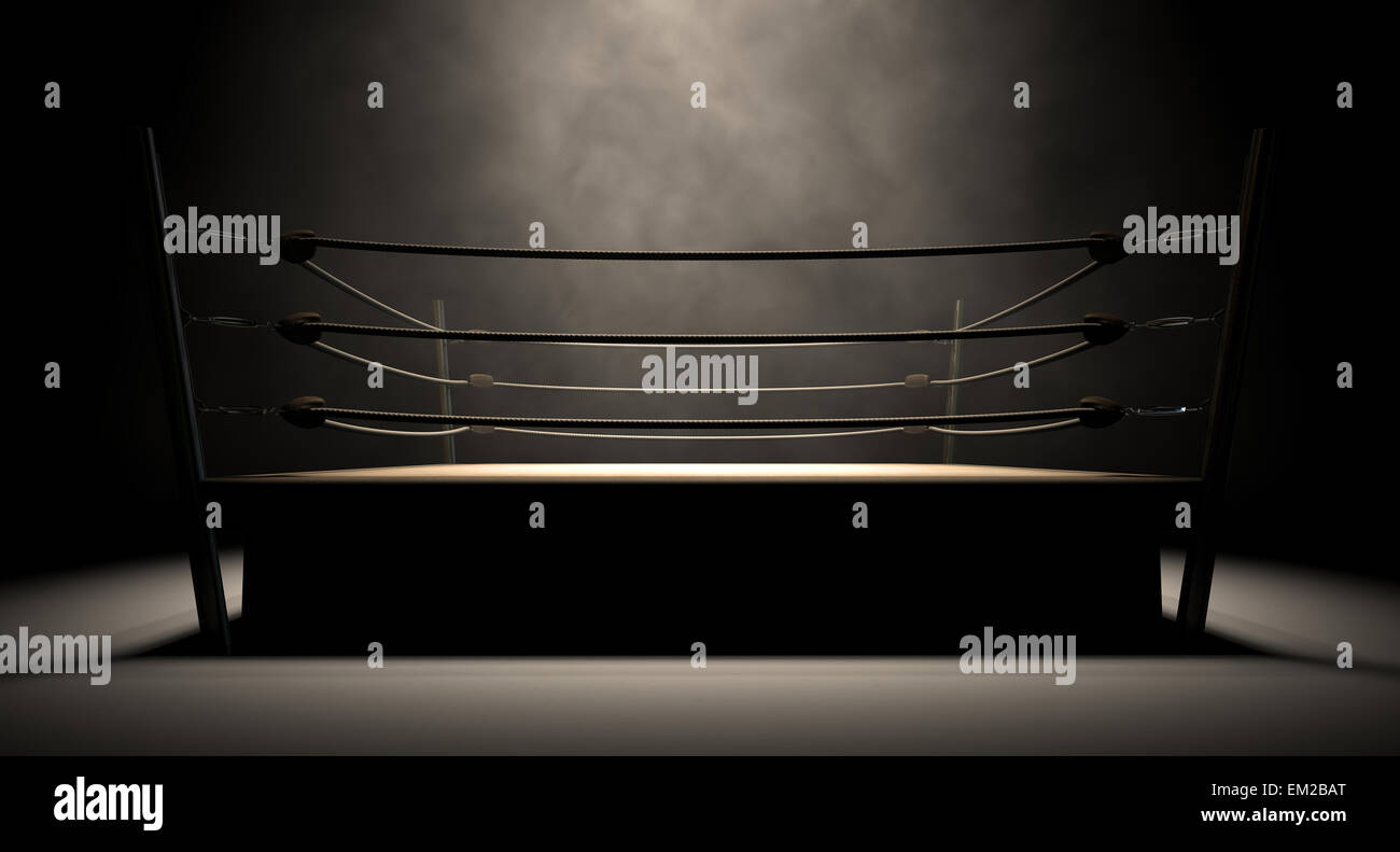 An old vintage boxing ring surrounded by ropes spotlit in the middle on ...