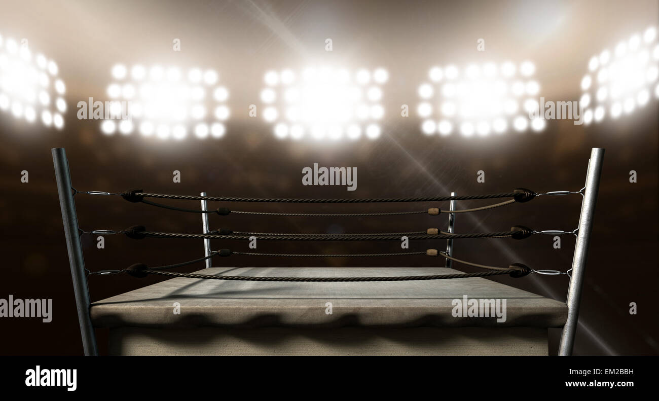 An old vintage boxing ring surrounded by ropes spotlit by floodlights ...