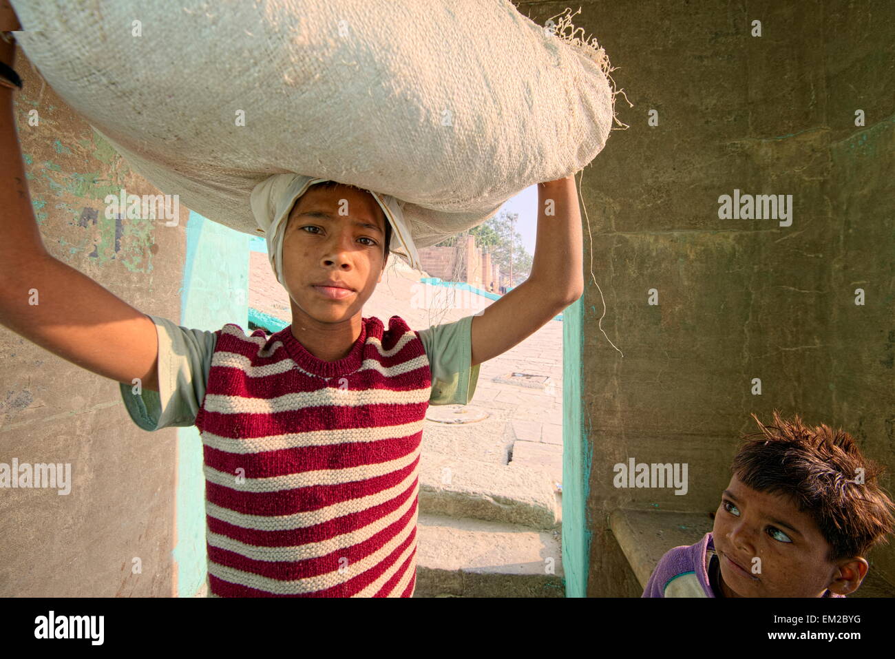 Boy carrying clothes washed at the waters of the Ganges Stock Photo - Alamy