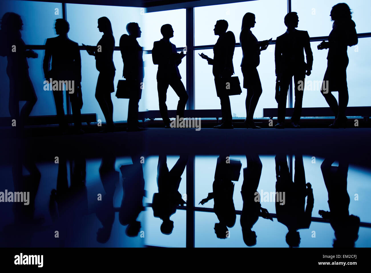 Interacting business partners standing by window Stock Photo - Alamy