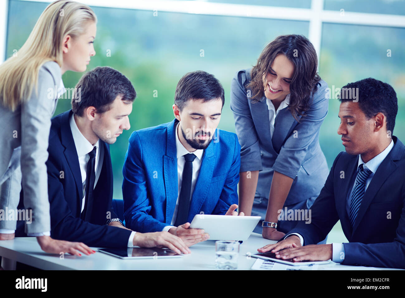Several confident employees gathered at workplace discussing data Stock ...