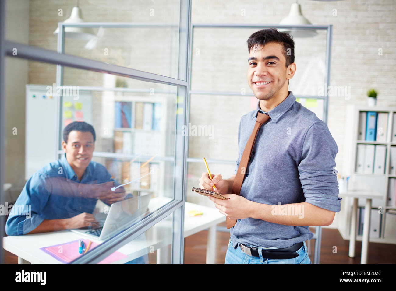 Young businessman making notes in office Stock Photo - Alamy