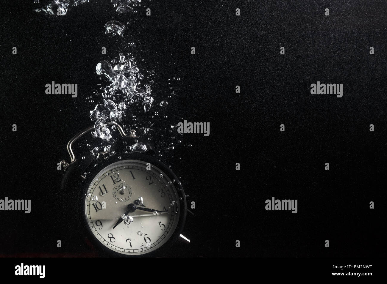 Concept of time. Vintage alarm clock in water with air bubbles. Photo ...