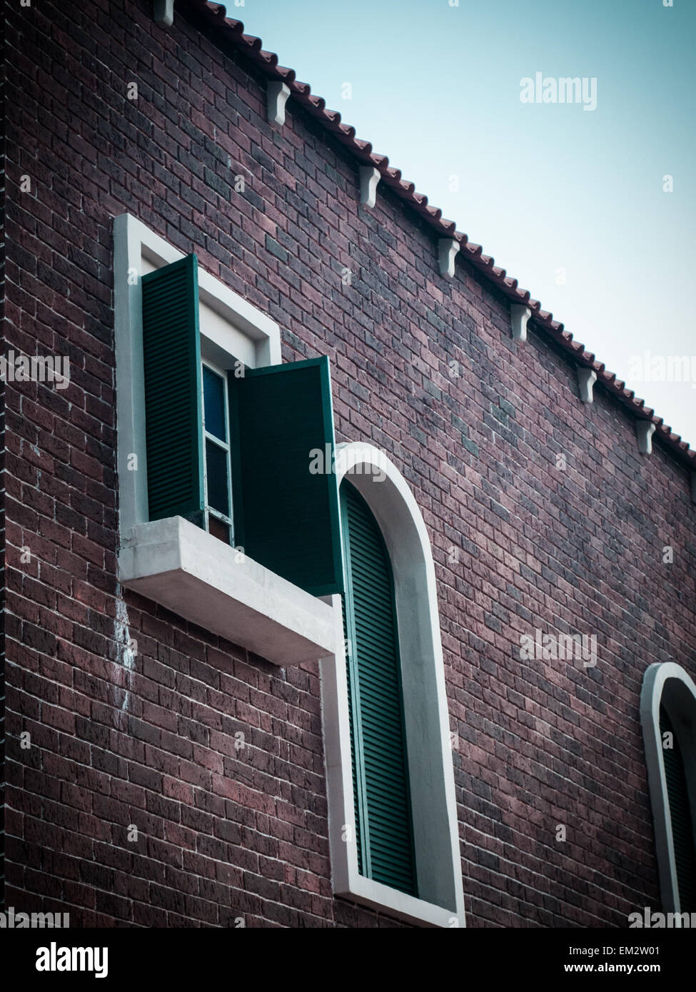 colorful glass and wooden shutter windows in brick wall background in ...
