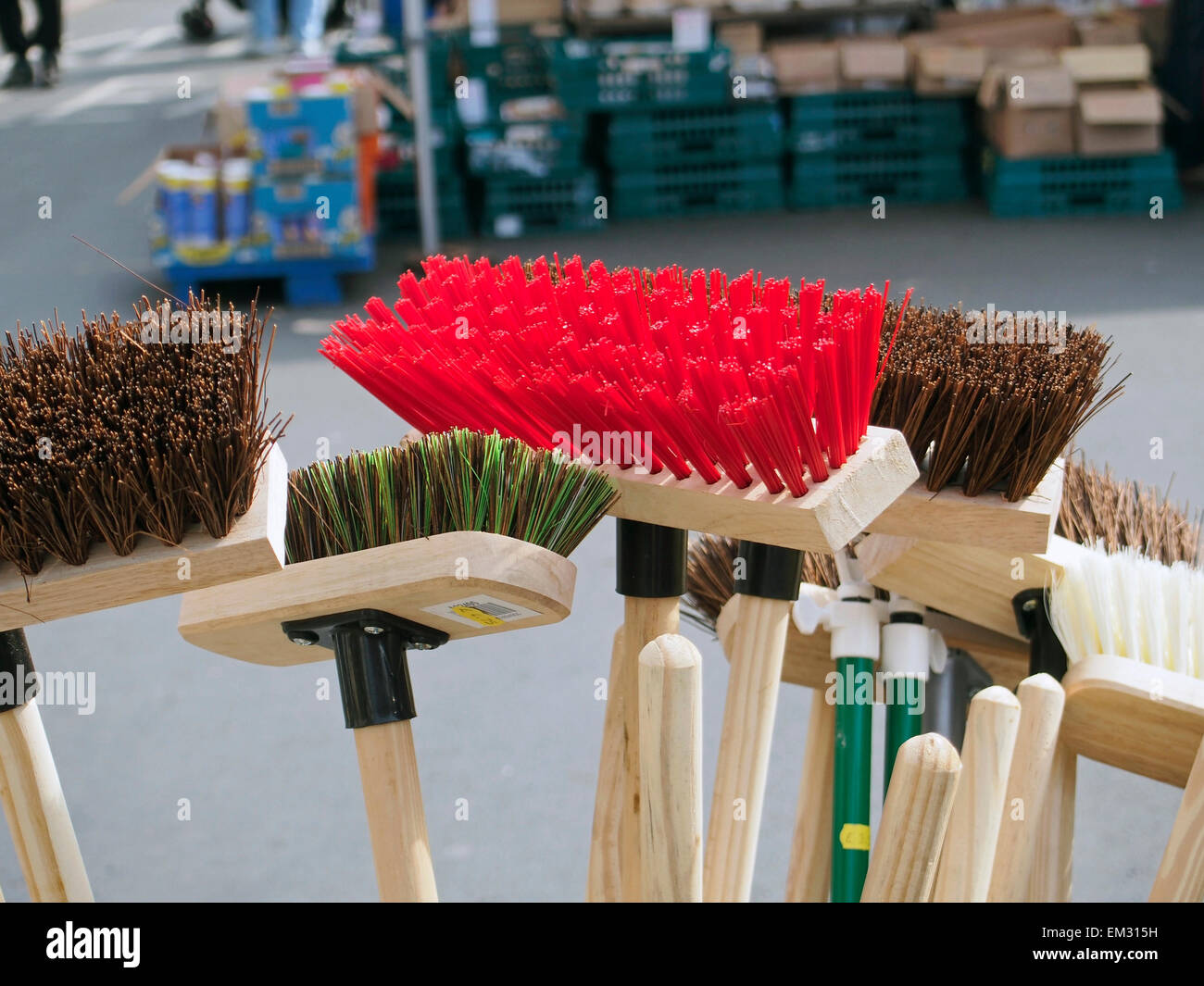 A bright red broom head stands out in this display on a market stall ...