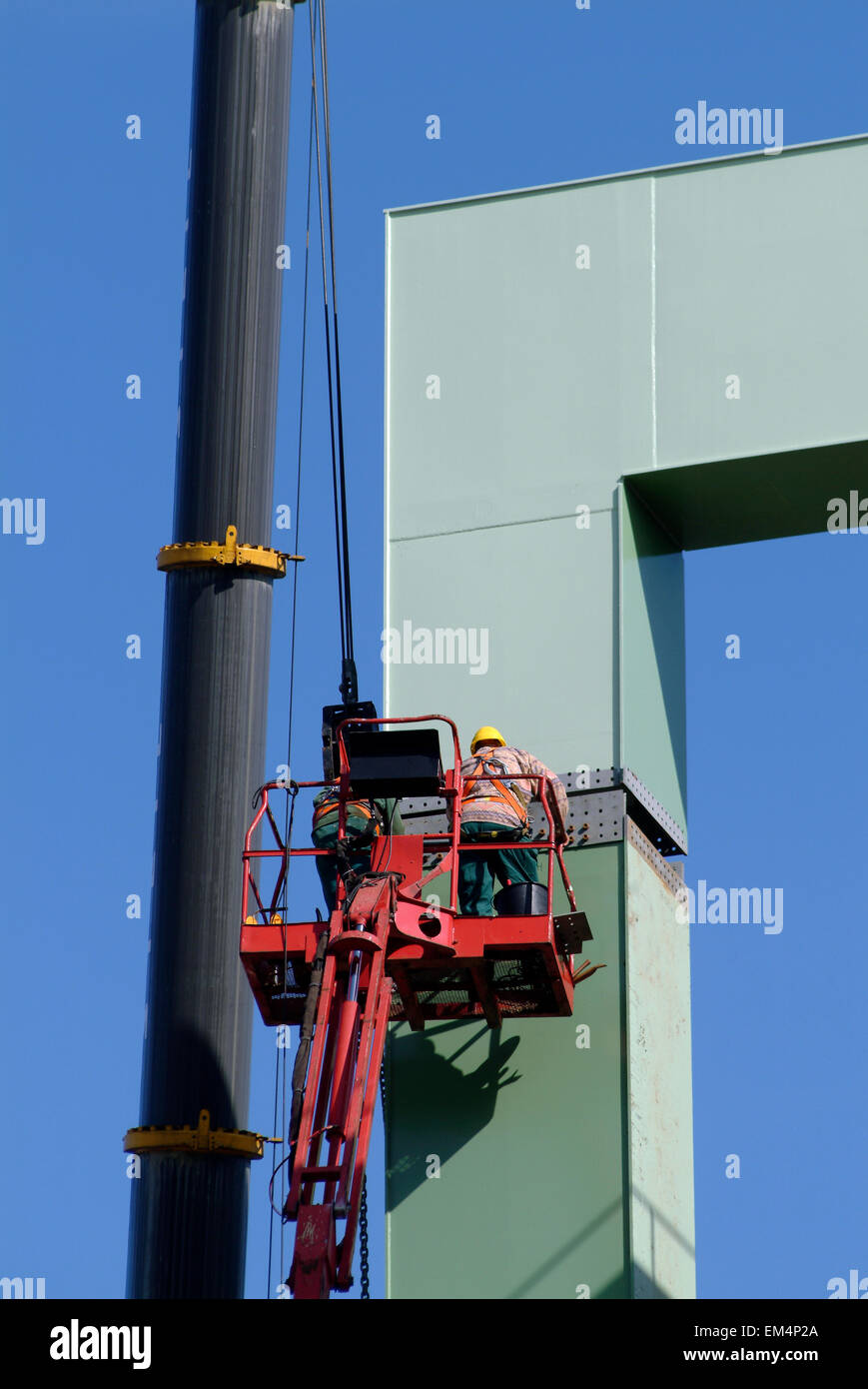 Two Worker installing a metal bridgehead in a harbor Stock Photo - Alamy